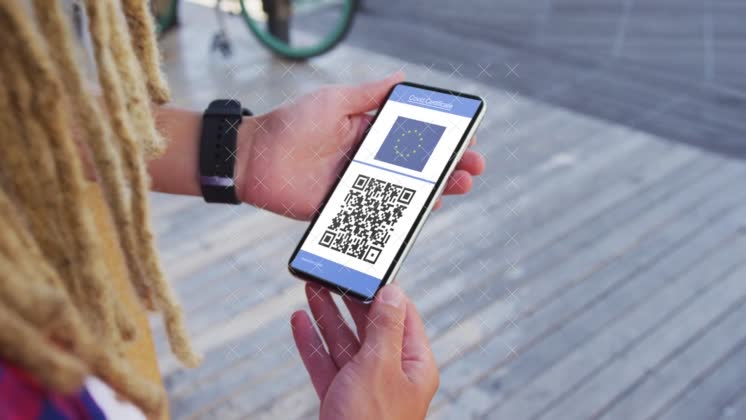 Video: Man with dreadlocks holding smartphone, covid vaccination certificate, eu flag and qr code on